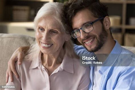 Happy Positive Senior Grandma And Handsome Grandson Guy Hugging Stock