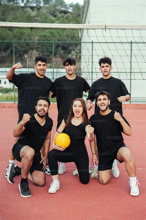 테니스 코트에서 사진을 찍기 위해 포즈를 취하는 한 무리의 사람들 사진 Unsplash의 팀 이미지