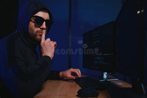 Hacker Sitting At Desk In Dark Atmosphere A Computer Programmer Or
