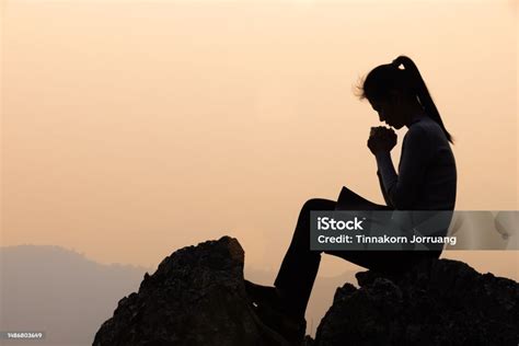 한 여성의 실루엣이 산에서 신에게 기도하고 있다 축복의 배경에서 종교에 대한 믿음과 하나님에 대한 믿음으로 기도하는 손 희망의