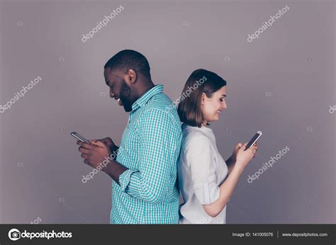 Двое расовых людей смотрят в телефон Красивая кавказская девушка стоковое фото ©deagreez1 141005076