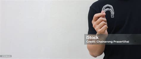 아름 다운 치아 치료 과정 개념을위한 흰색 배경에 치과 교정기 리테이너 도구 를 보여주기 위해 남자 손을 들고 닫기 개선에 대한