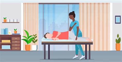 치유 치료 마사지 환자의 몸 수동 치료 물리 치료 개념 의료 캐비닛 인테리어 가로 하 고 테이블 전문 안마사 치료사에 앉아 젊은 남자 프리미엄 벡터