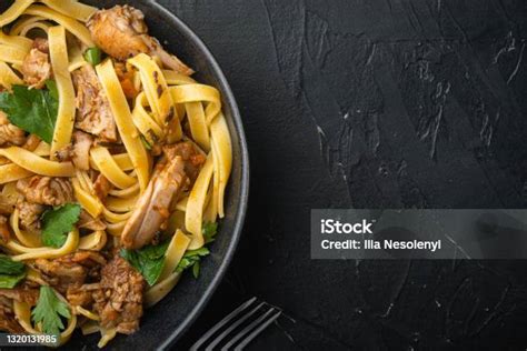 화이트 와인 소스 파스타 타글리아텔 또는 파파르델레에 야채와 야생 토끼 그릇에 검은 돌 배경에 상단 보기 플랫 누워 텍스트에 대 한 복사 공간 건강한 식생활에 대한 스톡
