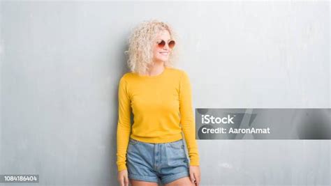 그런 지에 곱슬 머리 젊은 금발 여자 얼굴 자연의 표현에 미소 쪽으로 멀리 보고 배경 회색 자신감을 웃 고 있다 감정에 대한 스톡 사진 및 기타 이미지 Istock