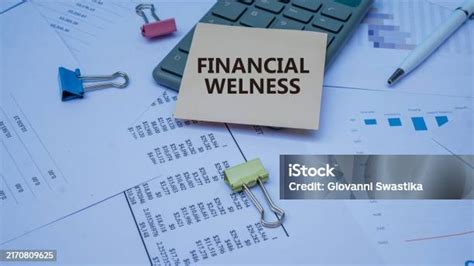 Financial Wellness 단어 공간을 복사합니다 개념 단어 Financial Wellness는 계산기와 배경에 다이어그램 차트가 있는 메모에 있습니다 비즈니스 및