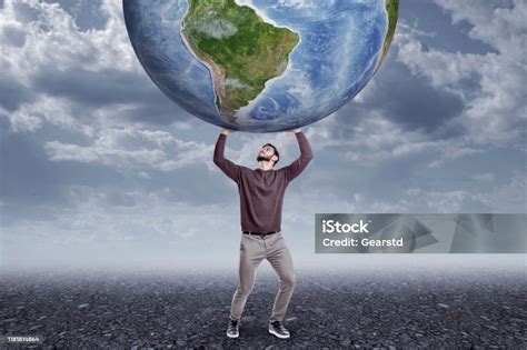 우울한 흐린 날에 큰 지구 지구를 들고 캐주얼 한 옷을 입은 젊은이의 전체 길이 전면보기 개념에 대한 스톡 사진 및 기타 이미지 개념 계획 남성 Istock