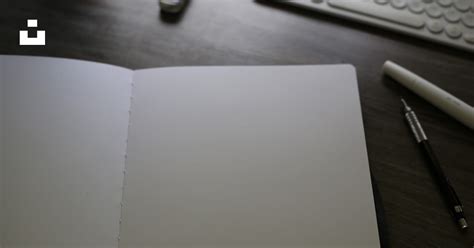 키보드 옆 책상 위에 놓인 열린 노트북 사진 Unsplash의 무료 종이 이미지