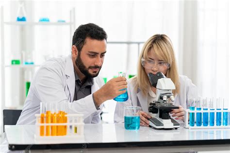Premium Photo Lab Worker Using Magnifying Glass On Microscope
