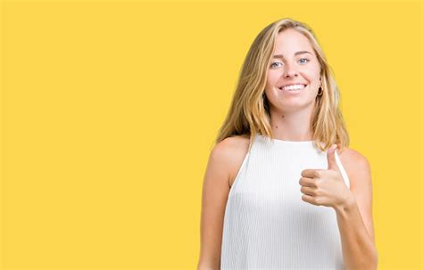 행복 한 엄지손가락 손으로 제스처를 하 고 격리 된 배경 위에 아름 다운 젊은 우아한 여자 승인 성공을 보여주는 카메라를 보고 하는 식 긍정적인 감정 표현에 대한 스톡 사진