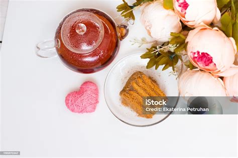 흰색 테이블에 유리 주전자에 홍차 투명한 접시에 꿀 케이크 조각 분홍색 꽃다발과 붉은 활이 달린 선물 세계 여성의 날 발렌타인 데이 꽃 식물에 대한 스톡 사진 및 기타