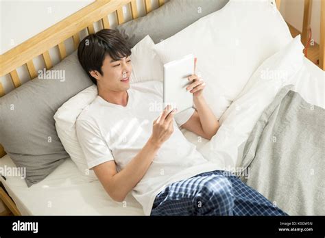 Smiling Single Man Resting Using Electric Tablet In Bed Stock Photo Alamy