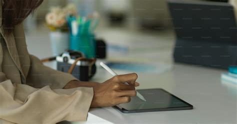작업대에 스타일러스 펜으로 디지털 태블릿으로 일하는 사업가 손의 측면도 사진 Unsplash의 여자 실업가 이미지