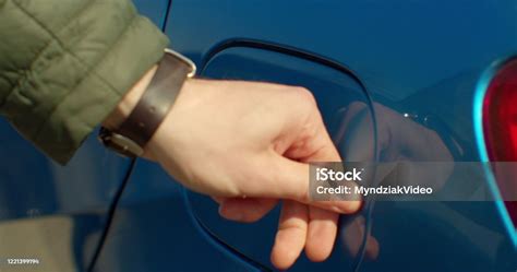 전기 충전 스테이션에서 집에서 하이브리드 자동차에 연결하는 남자 럭셔리 블루 전기 자동차 충전 자신의 전기 자동차를 충전 환경 의식이 남자 교통수단에 대한 스톡 사진 및