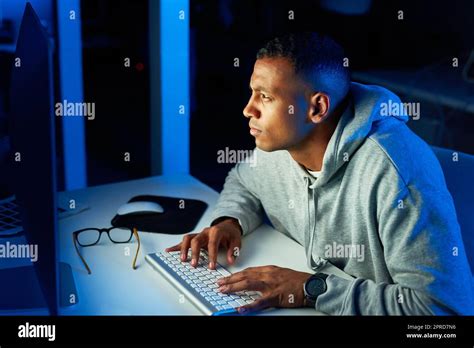 Hes Got His Eyes On His Next Victim A Young Male Hacker Cracking A Computer Code In The Dark