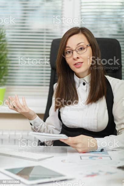 아름 다운 미소 브라운 헤어 비즈니스 여자 양복과 태블릿 책상에 앉아 안경 빛 사무실에서 문서는 컴퓨터에서 작업 노트북 연필 정보 작성 경영자에 대한 스톡 사진 및 기타