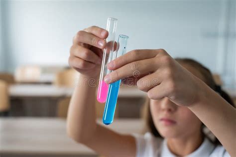 A Schoolgirl Conducts Experiments In A Chemistry Lesson The Girl Compares Two Test Tubes With