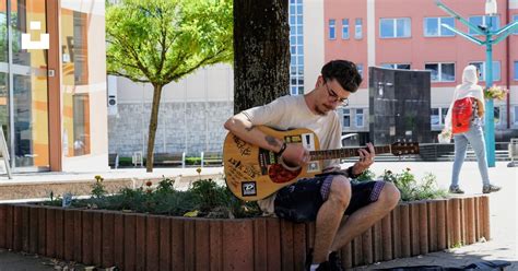 갈색 어쿠스틱 기타를 연주하는 흰색 티셔츠를 입은 남자 사진 Unsplash의 무료 보스니아 헤르체고비나 이미지
