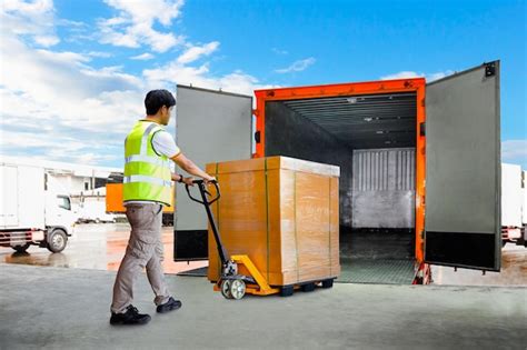 Premium Photo Workers Unloading Heavy Pallet Boxes Into Container Truck Supply Chain Shipment