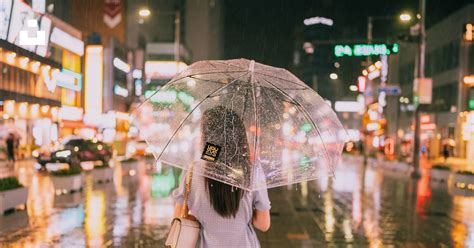 한 여자가 우산을 들고 빗속을 걷고 있습니다 사진 Unsplash의 무료 비 이미지