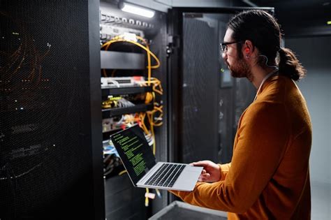 Premium Photo Bearded It Engineer Using Laptop While Setting Up Network In Server Room