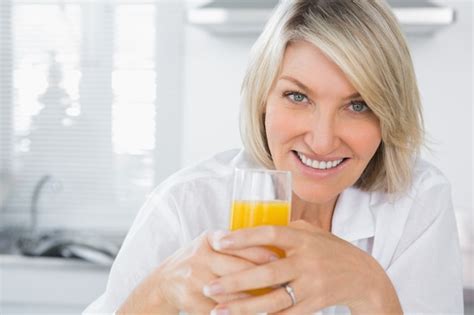 Premium Photo Happy Blonde Having Orange Juice In Kitchen
