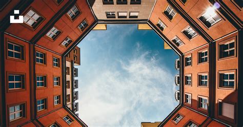 낮 동안 흰 구름과 푸른 하늘 아래 육각형 주황색과 갈색 콘크리트 건물의 로우 앵글 사진 사진 Unsplash의 무료 베를린 이미지