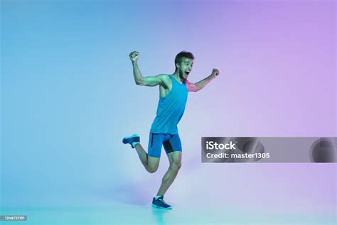 활동적인 젊은 백인 달리기의 전체 길이 초상화 네온 빛에 그라데이션 스튜디오 배경에 조깅 남자 개념에 대한 스톡 사진 및 기타