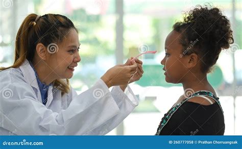 Professional Optician Helping Girl Choosing Spectacles Glasses In Optic