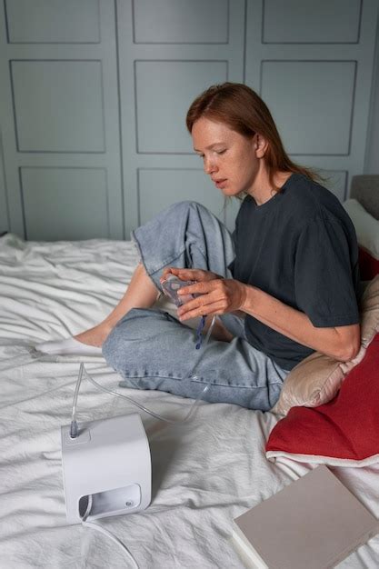Premium Photo Full Shot Woman Using Nebulizer At Home