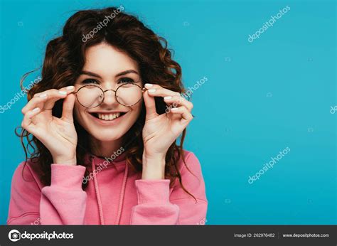 Cheerful Curly Redhead Girl Touching Glasses Isolated Blue — Stock