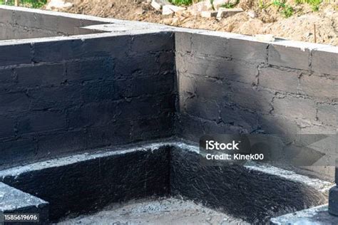 검은 색 분산 아스팔트 고무 덩어리로 칠해진 콘크리트 블록으로 만든 기초 철근 콘크리트 기둥이 보입니다 0명에 대한 스톡 사진 및 기타 이미지 Istock