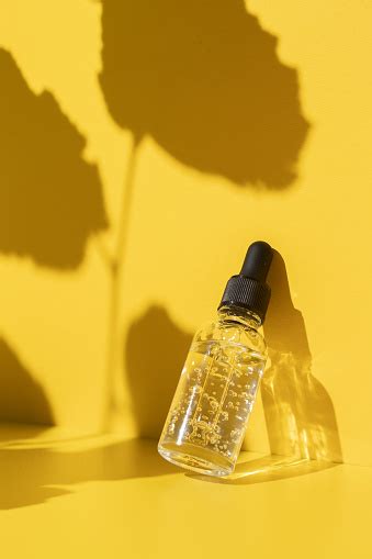 나뭇잎 그림자가있는 노란색 배경에 유리 점적기 병을 모의하십시오 화장품 얼굴 피부 관리 및 스파 자연 치료 개념 강단에 대한 스톡 사진 및 기타 이미지 Istock