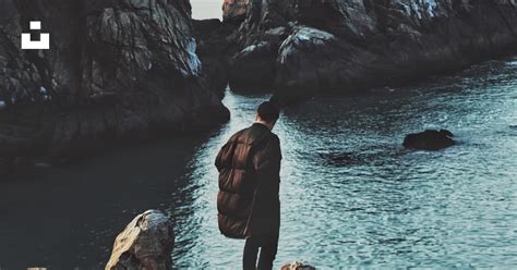 물 속의 바위 위에 서 있는 사람과 바위 위에 앉아 있는 사람 사진 Unsplash의 무료 해안선 이미지