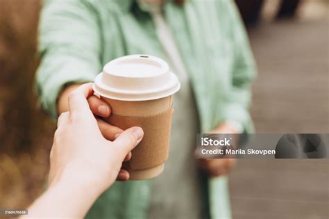 여자가 종이 커피 컵을 준다 테이크 아웃 또는 배달 개념 공간을 복사합니다 머그잔에 텍스트 또는 로고를 배치하고 모형을 만드십시오 여자가 컵을 마신다 2명에 대한 스톡 사진