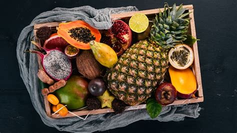 나무 상자에 열 대 과일입니다 파파야 드래곤 과일 람 부탄 타마린드 선인장 과일 아보카도 Granadilla Carambola 금 귤 망고 망고스틴 시계 꽃 열매 코코넛