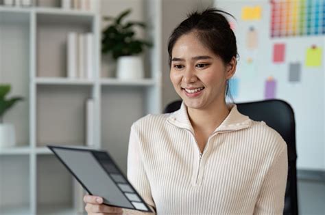 혁신적인 디자인 프로젝트를 위한 색상 견본과 디지털 도구를 사용하여 현대적인 사무실에서 작업하는 창의적인 그래픽 디자이너 Vogue Fashion Fund에 대한 스톡 사진