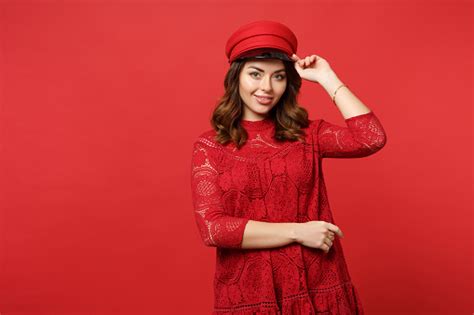 레이스 드레스 지주 모자 카메라를 찾고에서 웃는 젊은 여자의 초상화 스튜디오에서 밝은 붉은 벽 배경에 고립 서 서 사람들은 진심으로 감정 라이프 스타일 개념입니다 복사