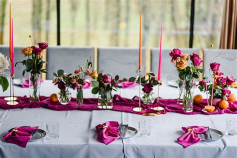 분홍색과 주황색 꽃 장미와 양초 과일로 장식 아름답게 조직 된 이벤트 홀에서 손님을 위해 준비된 테이블 연회 생일 파티나 결혼식 피로연을 위한 테이블 세트 0명에 대한 스톡