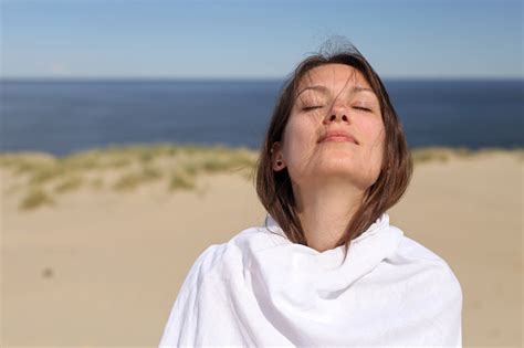 눈을 감고 흰 천으로 감싸 아름 다운 어두운 머리 젊은 흰색 유럽 여자 닫습니다 리투아니아의 니다 에 있는 파 니 디스 듄에 게로 탄 침에서 촬영 푸른 하늘과 맑은 날