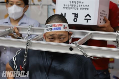 삭발 후 머리에 띠를 두른 신경수 팀장 쇠사슬로 묶인 사다리를 목에 걸었다 사진 하민지