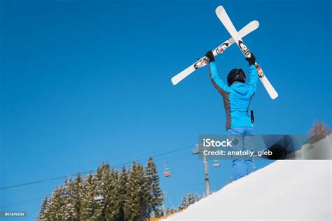 맑은 겨울 날 산의 사면에 포즈 머리 Copyspace 푸른 하늘 숲 스키 리프트는 배경에서 그녀의 스키를 들고 여성 스키어의