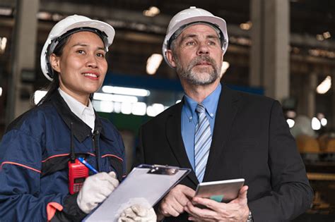 공장 예비품에서 여분을 가진 아시아 엔지니어 여성과 함께 일하는 백인 엔지니어 관리자 2명에 대한 스톡 사진 및 기타 이미지 2명 40 44세 55 59세 Istock