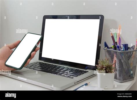 Mock Up Hand Holding Smartphone White Blank Screen And Computer Laptop