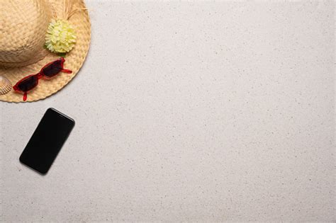 여름 해변 휴가 컨셉으로 자유로운 텍스트 공간을 즐길 수 있다 평면도 여성용 밀짚모자 선글라스 스마트폰 고운 모래 배경에 조개껍데기가 있는 평면 레이아웃 관광에 대한 스톡