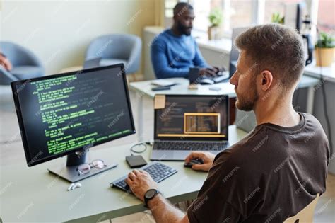 Premium Photo Portrait Of Software Engineer Writing Code At Workplace In Office With Multiple