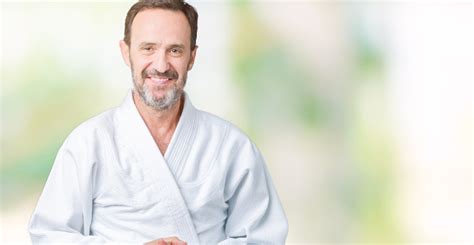 잘생긴 중 년 수석 남자 이상의 기모노 유니폼을 입고 함께 배경 손을 분리 하 고 손가락이 편안 하 고 밝은 미소 성공이 고 낙관적 가라테에 대한 스톡 사진 및 기타 이미지