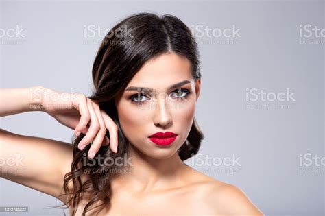 빨간 립스틱과 아름다운 젊은 패션 여성 얼굴의 깨끗한 피부를 가진 갈색 머리 여자 밝은 빨간 입술모델의 초상화 스튜디오에서 포즈를 취하는 밝은 광택 메이크업과 매력적인 패션
