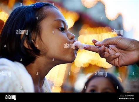 Cute Little Asian Girl Licking Her Mothers Finger Which Has Candyfloss