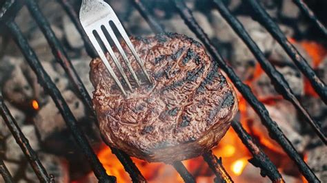 A Juicy Beef Steak With A Barbecue Fork Stuck On Hot Coals With Smoke And Sparks Stock Footage
